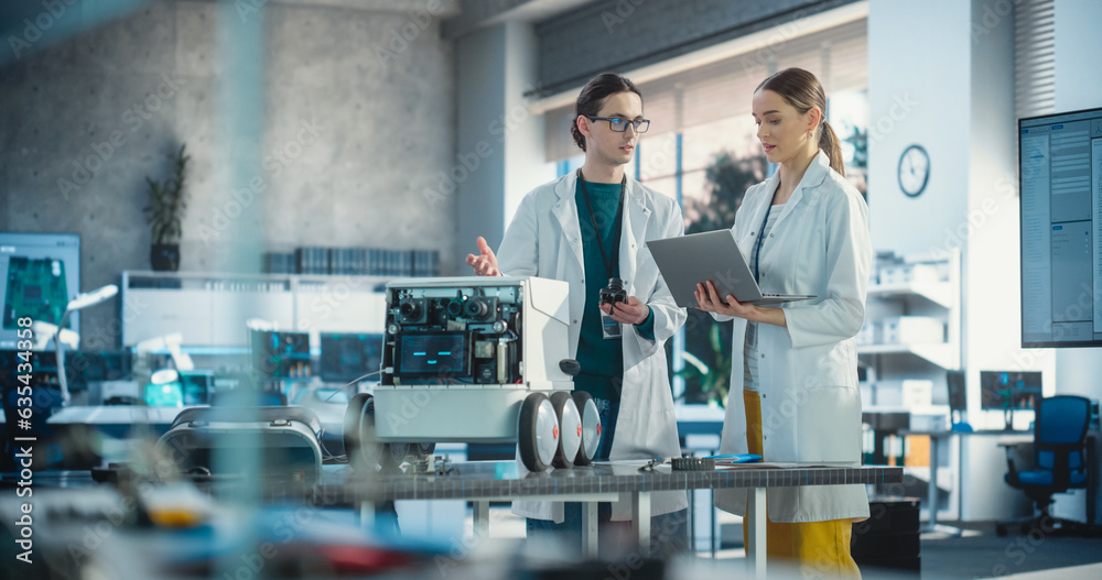 Two Industrial Robotics Specialists Working on a Mobile Robot, Using ...