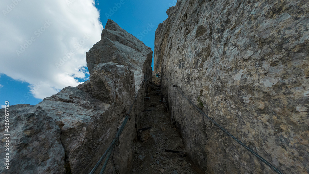 Description: A narrow rocky passage with steel cables and metal ...