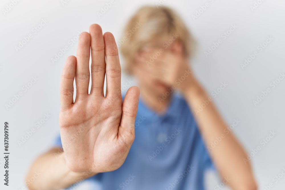 Young modern man standing over isolated background covering eyes with ...