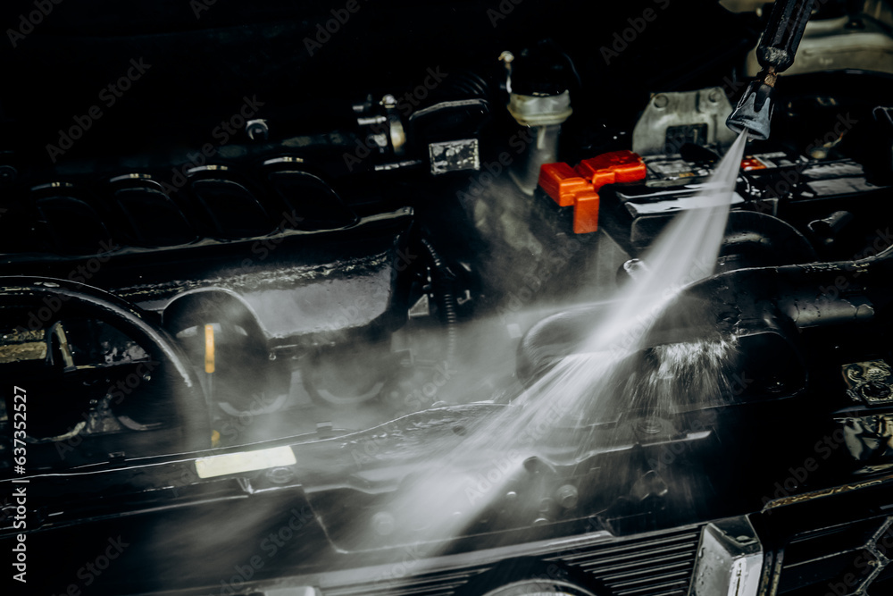 Washing the car engine under strong water pressure. Car maintenance ...