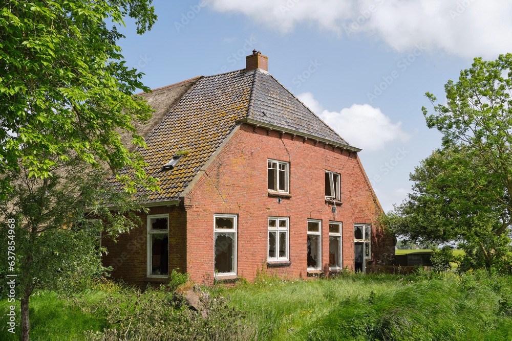 An abandoned and dilapidated farm house with red bricks and broken ...