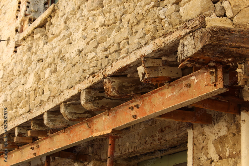very old medieval stone building with wooden beams needing to be held ...