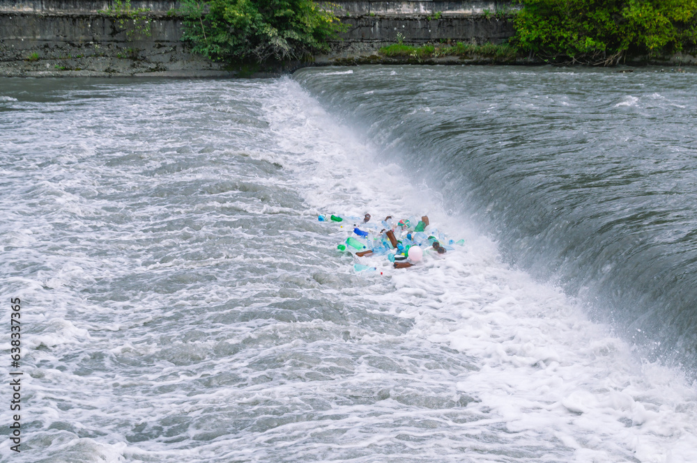 Plastic garbage floats in the river. Plastic bottles in the river ...