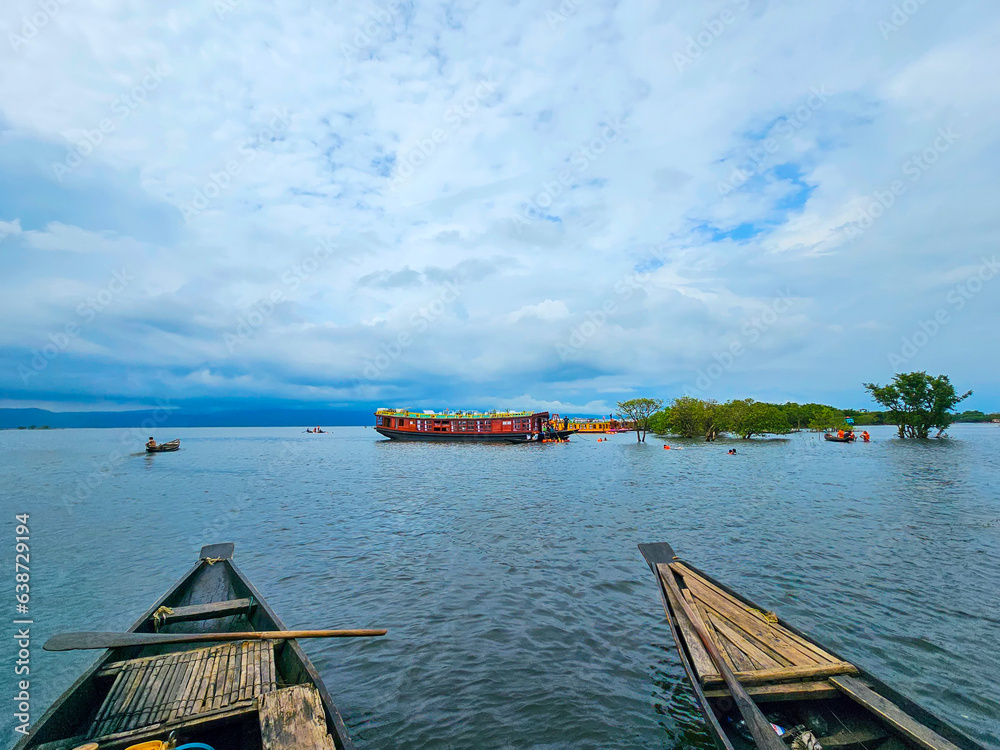 Traditional baots with a houseboat at the Tanguar Haor in Sunamganj, a ...