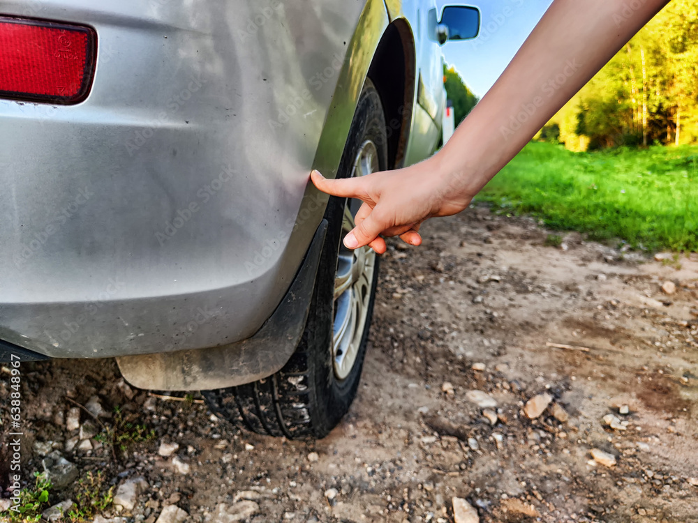 The child points at a scratch on the car. The child's hand scratches ...