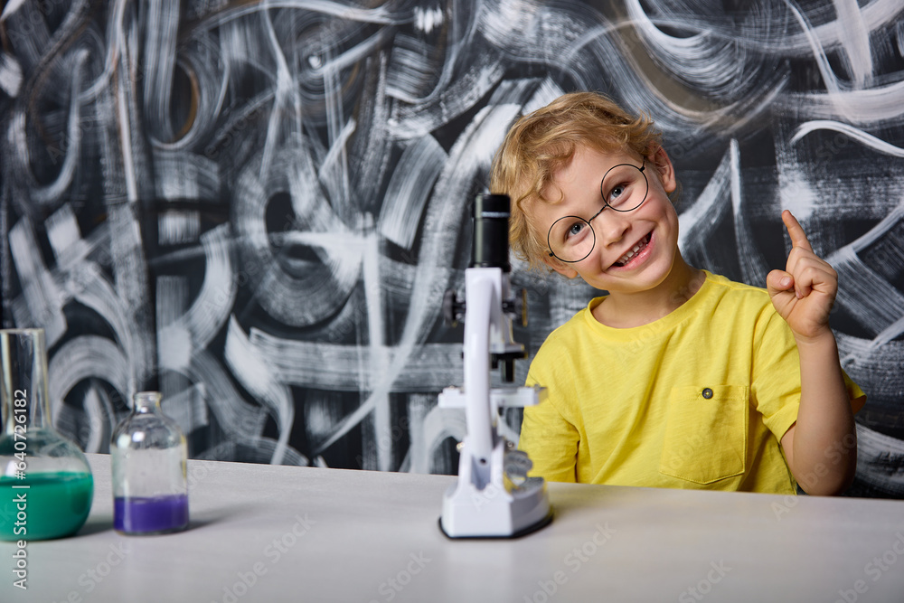 In children laboratory little boy looks different substances through ...