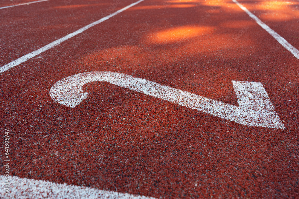 Running track lane number, starting line sign. Surface with lines and ...