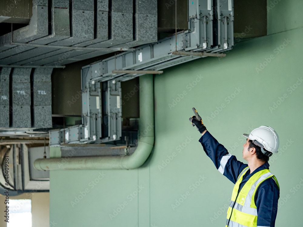 Building inspector man checking telephone cable duct wireway. Asian ...