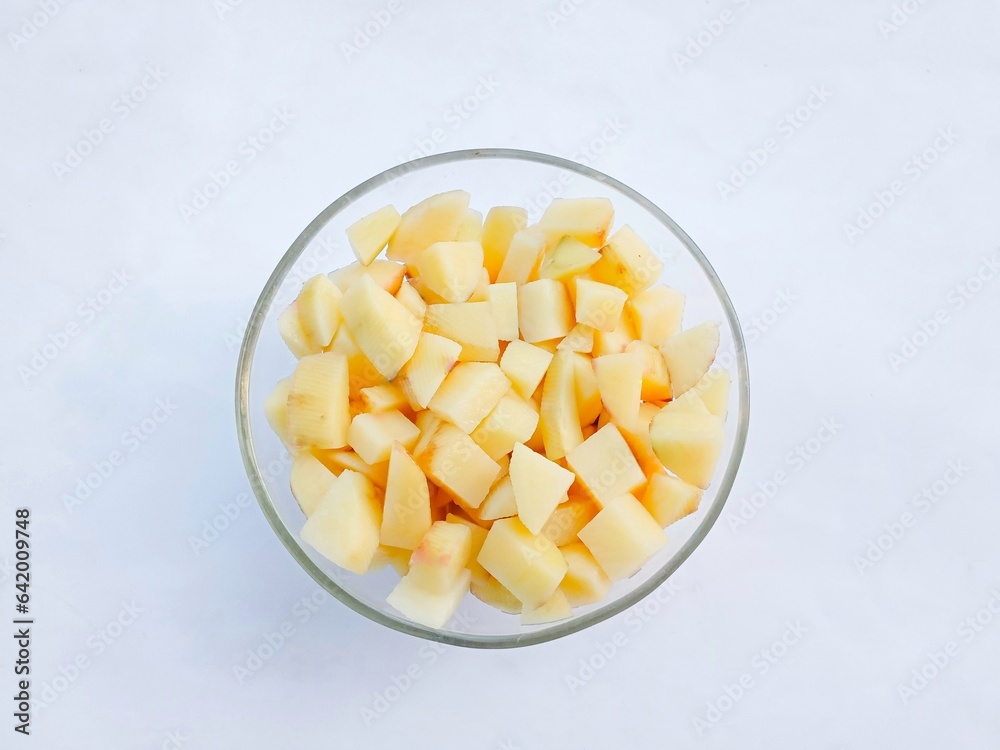 Diced raw potatoes in a glass bowl on a white background. vegetables ...