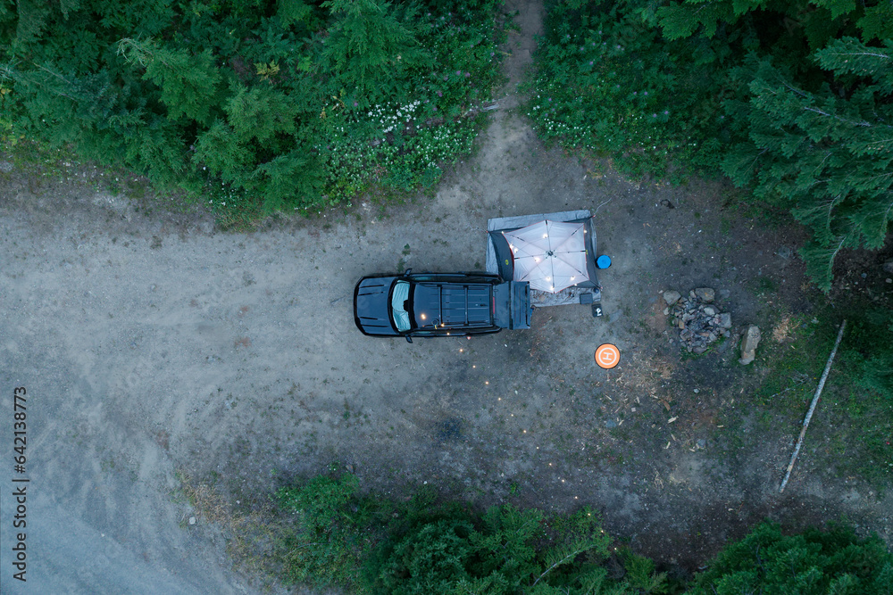 Bird's eye view of a campsite with parked suv, sting lights, drone ...