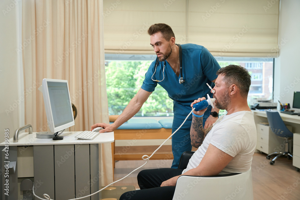 Adult man taking spirometry test in presence of doctor Stock Photo ...