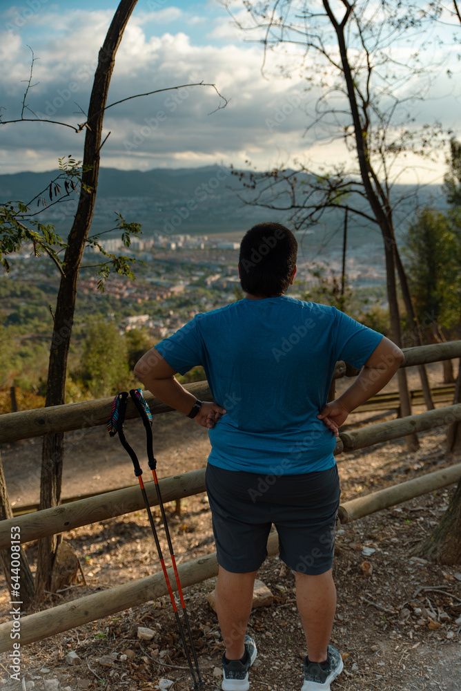 Overweight man stops his training to contemplate the landscape in the ...