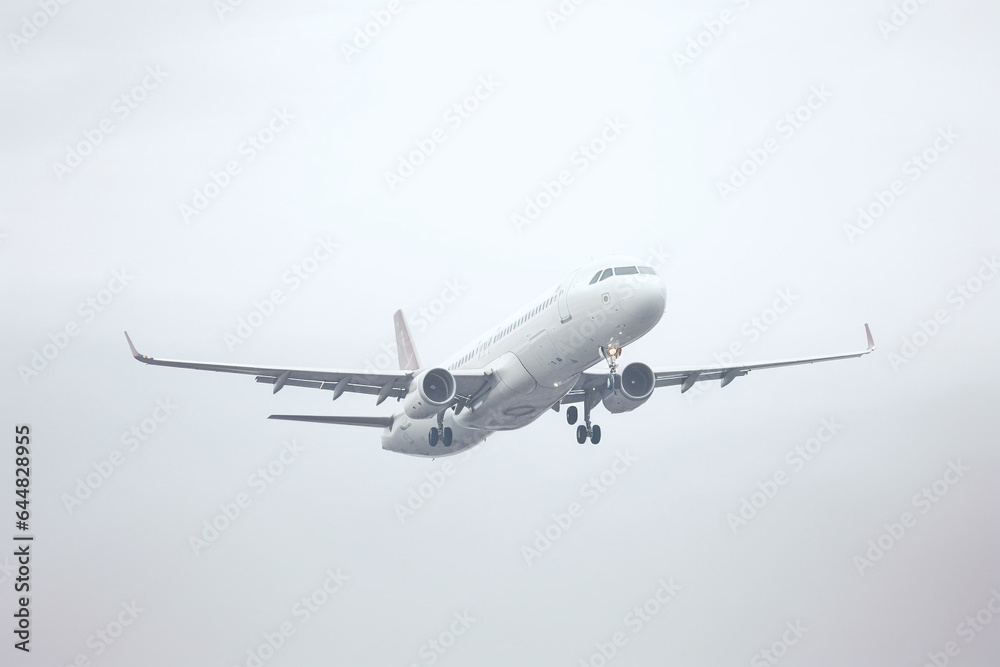 A white aircraft glides through the sky against a spotless white ...