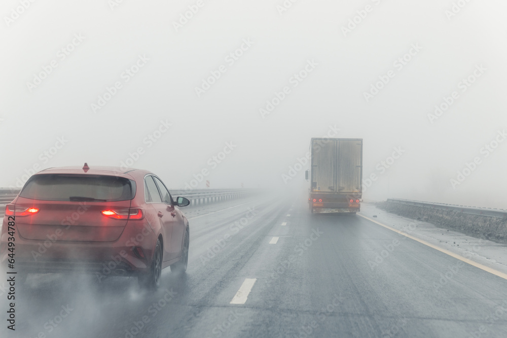 Driver POV on traffic on blue foggy misty rainy slush highway intercity ...