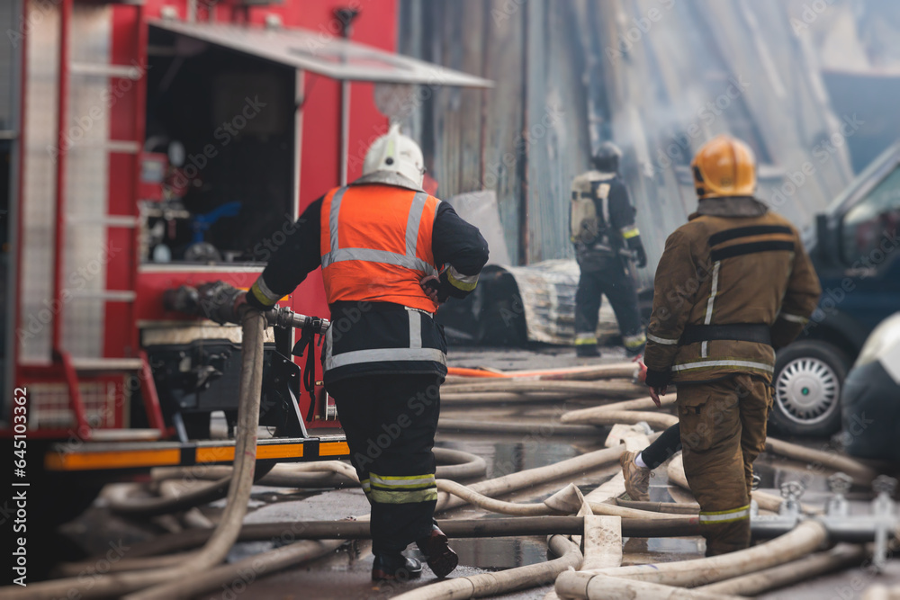 Group of fire men in protective uniform during fire fighting operation ...