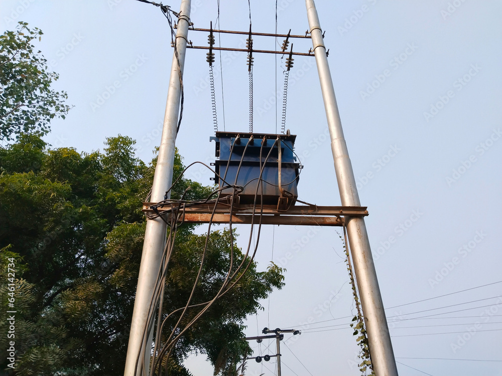 High voltage transformer against the blue sky. Electric current ...