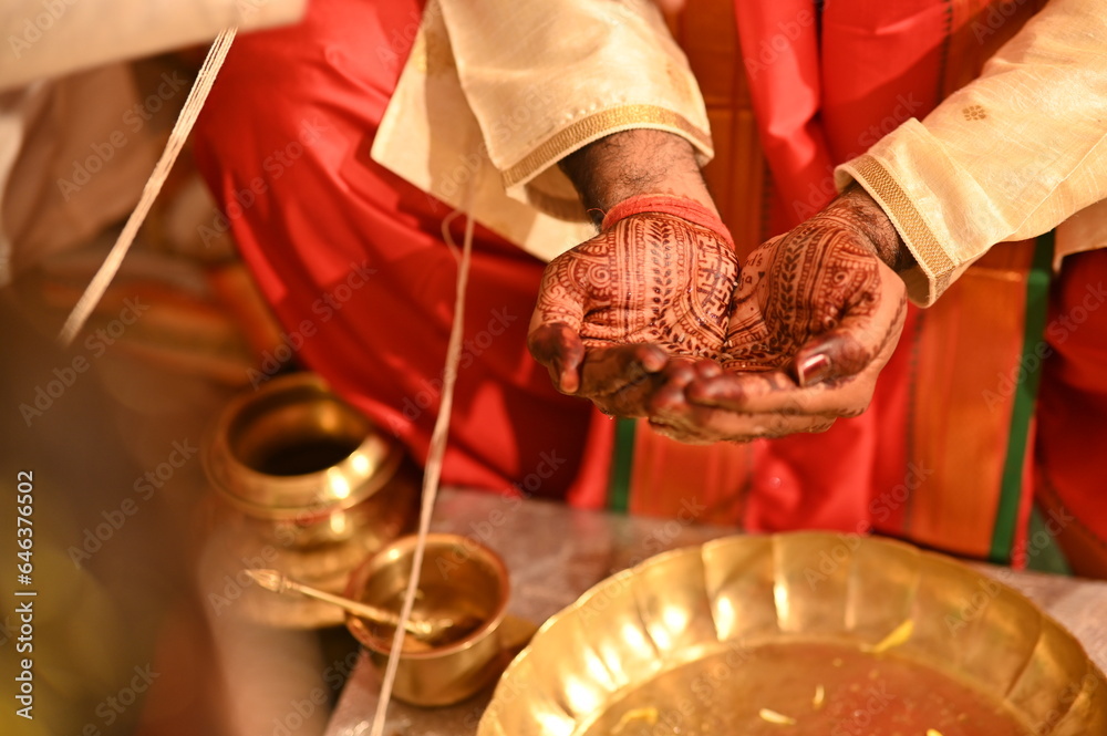 Water drops on the Indian groom hands. Plate with petals and water ...