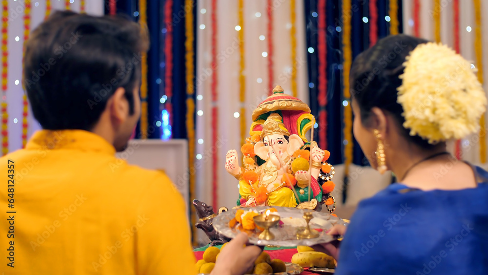 Stockfoto An Indian couple worshipping Lord Ganesha - puja ki thali ...