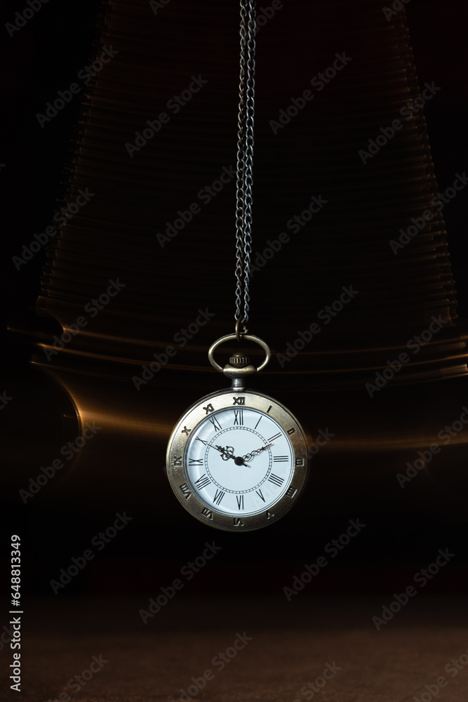 Hypnosis session. Vintage pocket watch with chain swinging over surface ...