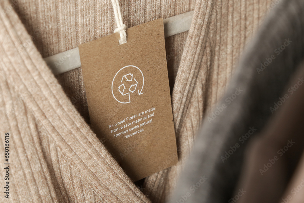 Close up of clothing tag with recycle icon. Recycling products concept ...