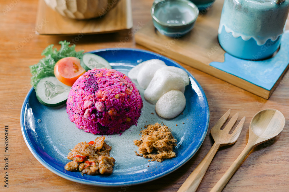 Pink fried rice made from dragon fruit served with tempeh, kerupuk ...