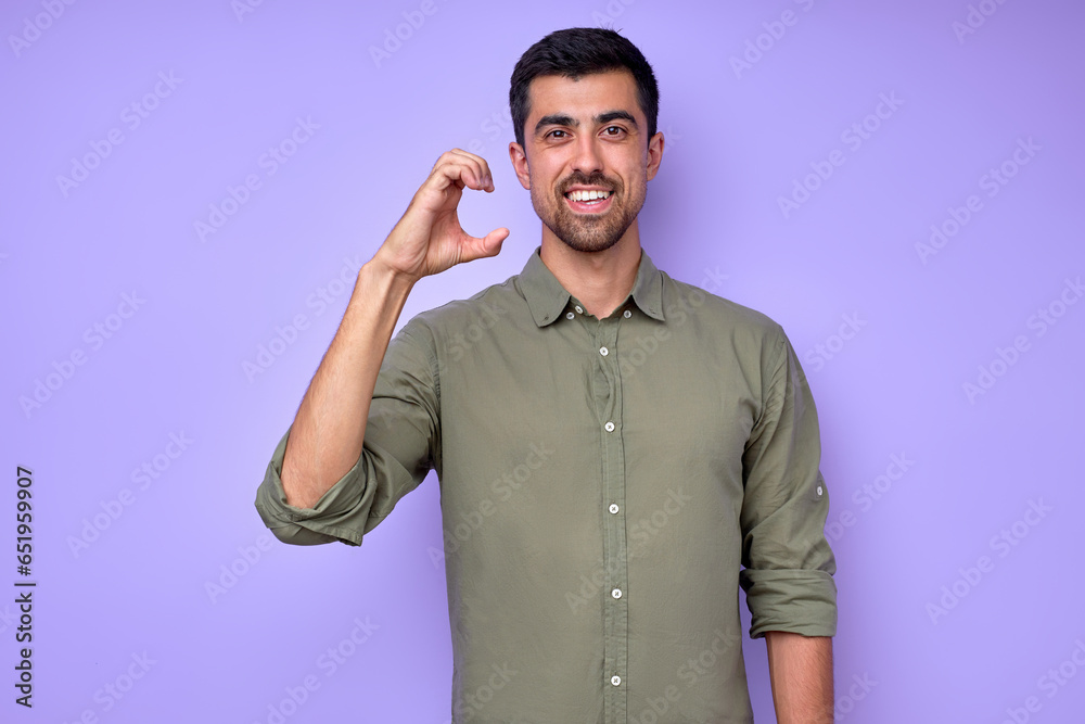 Young smiling deaf man wearing green shirt using sign language on blue ...