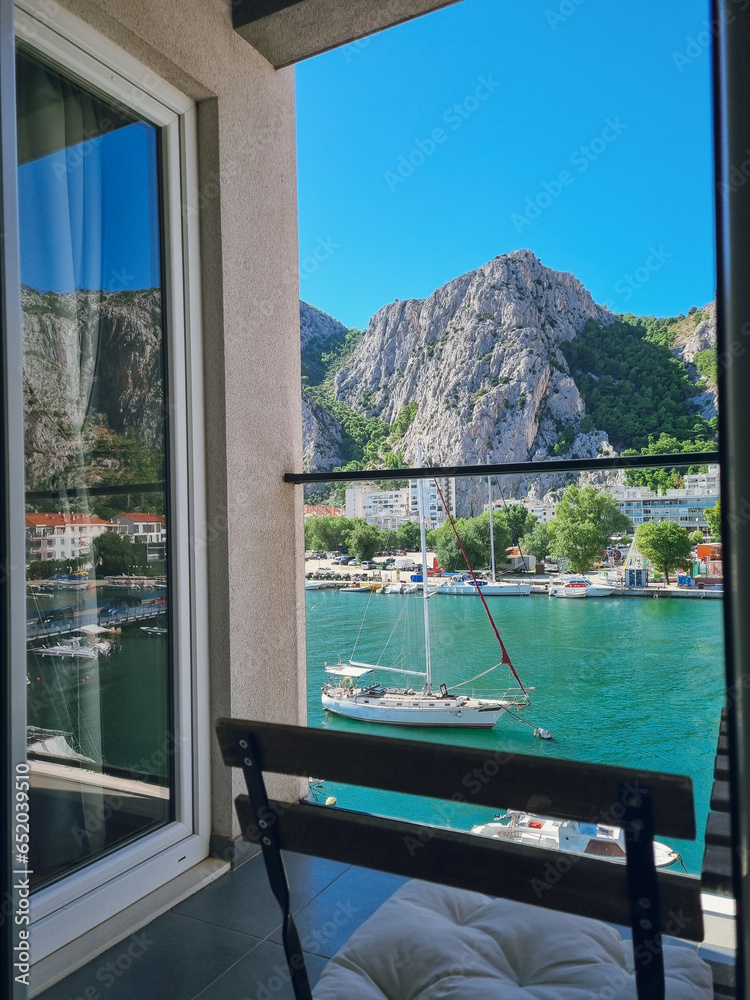 Balcony view with panorama to Emerald-green Cetina River with yachts and rocks in view, Omis ...
