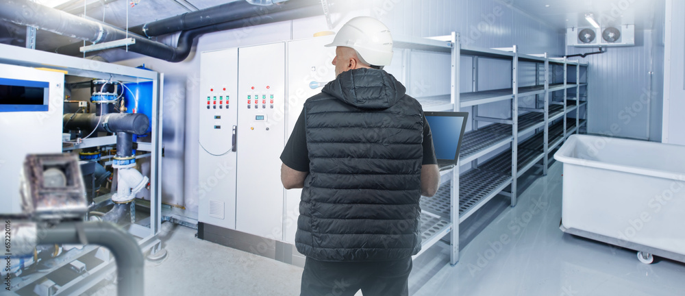 Engineer inside cold storage warehouse. Man inspects industrial ...