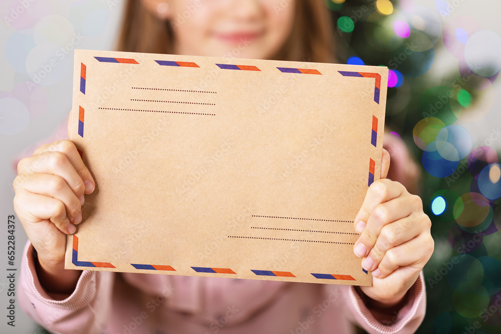 A child holds an empty mail envelope in front of him in his hands ...