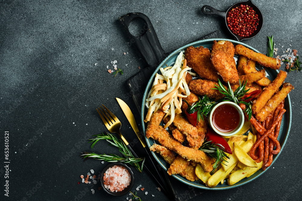 Fast food. Plate with snacks: nuggets, sausages, French fries, cheese ...