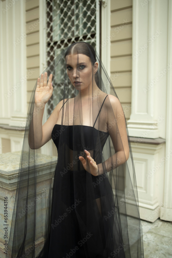 girl 30 years old in a sexy, designer, black dress, black veil, posing ...