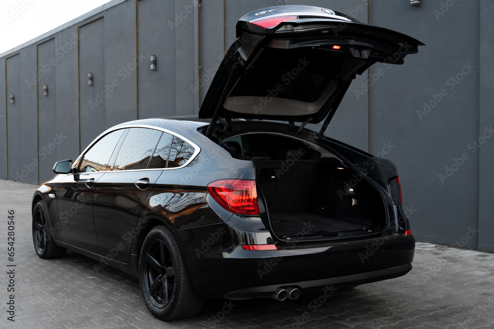Premium black auto parked at urban are with open trunk. Well-designed ...