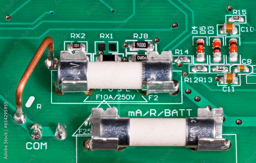 Closeup of ceramic tubes of electrical fuses in metal holder on circuit ...