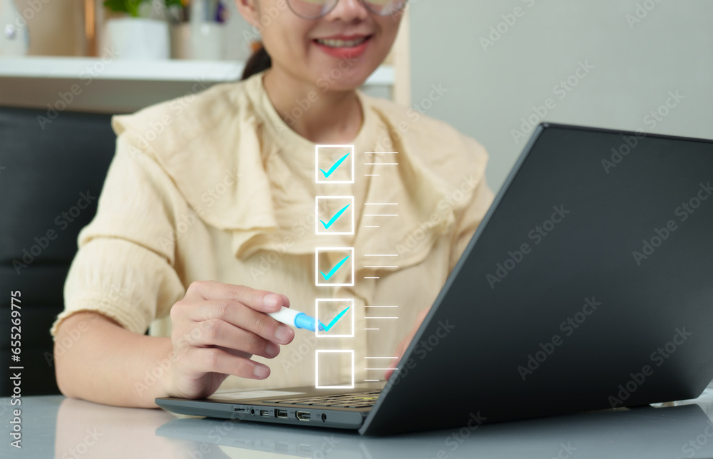 Asian woman ticking check mark on online survey evaluation form ...