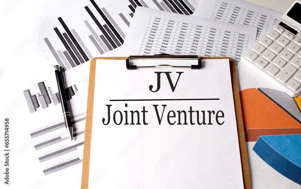 Paper with JV Joint Venture on a chart background, business concept ...