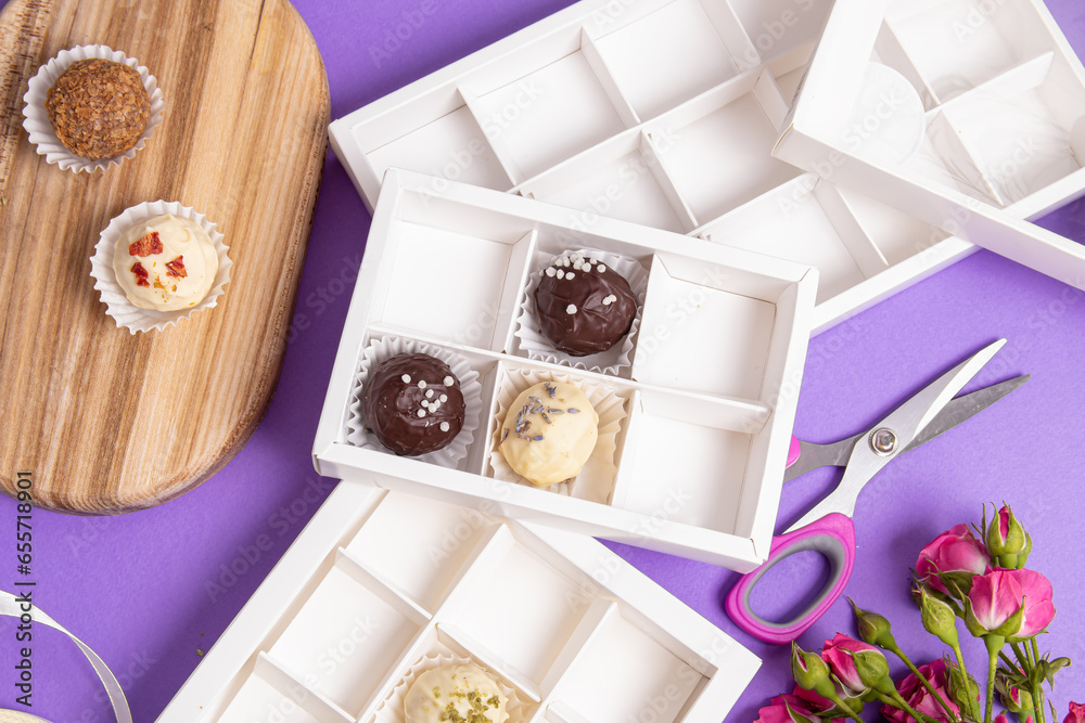 Process of packing sweets into gift boxes. Cheese truffles, boxes and ...