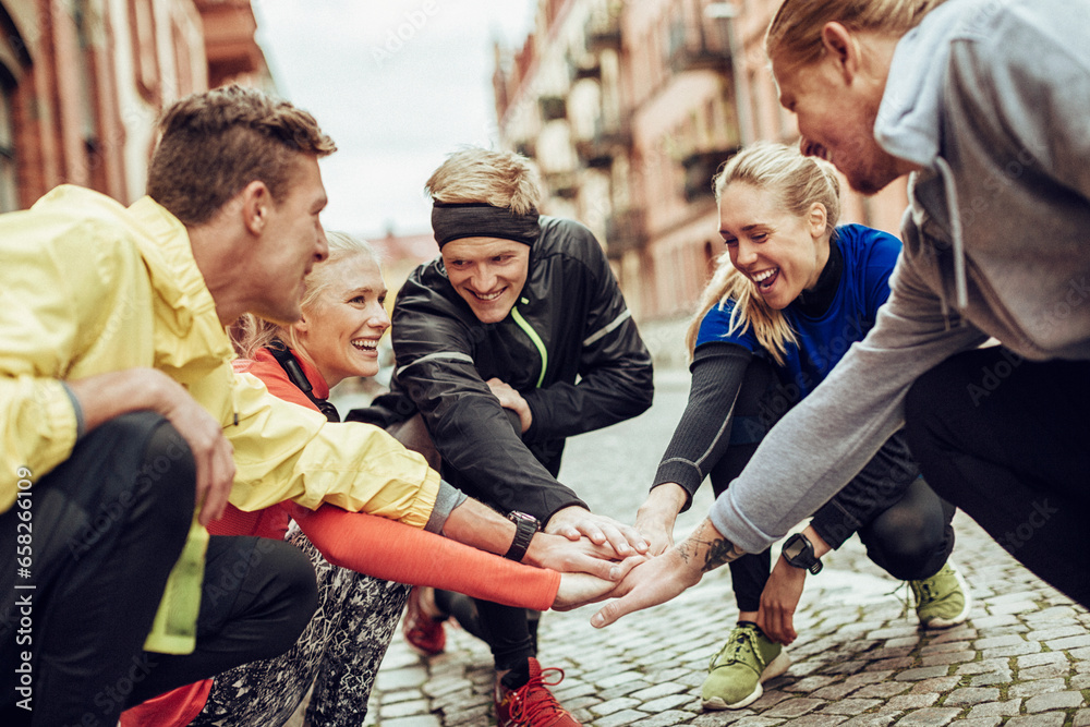 Young a diverse group of friends showing teamwork and stacking hands ...