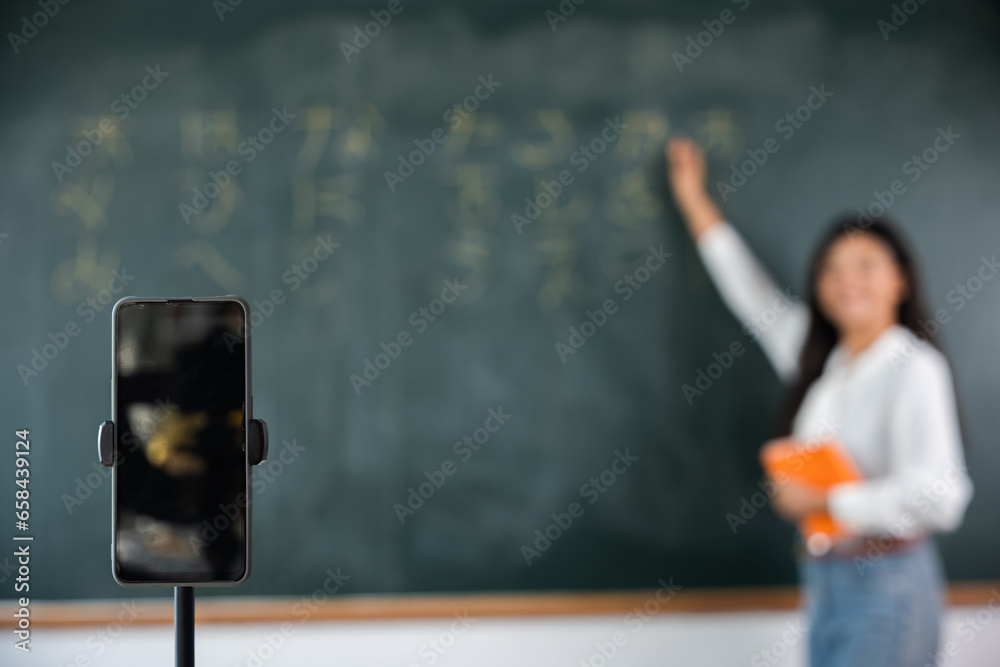 Back to school online class. Asian teacher teach on board while have blackboard lecture online ...