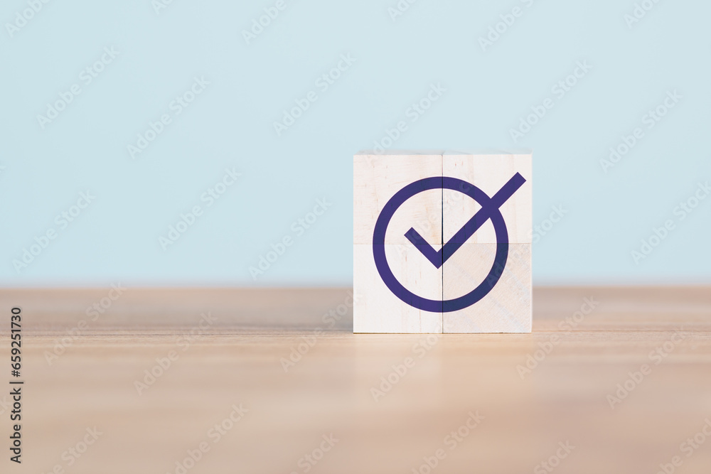Wooden cube block with checkmark icon on wood table. Goals achievement ...