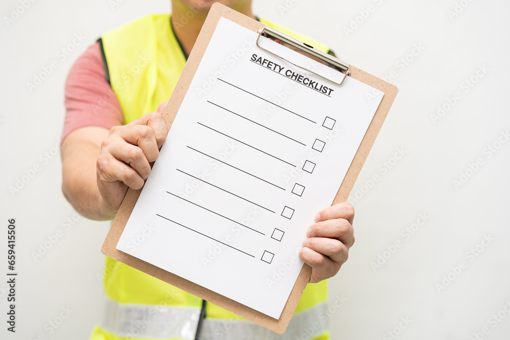 Staff holding blank checking on safety checklist form. Hand of staff is ...