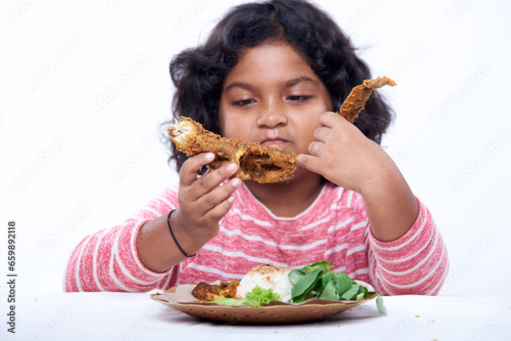 Little asian girl eating crunchy Fried Fish with rice and vegetable ...