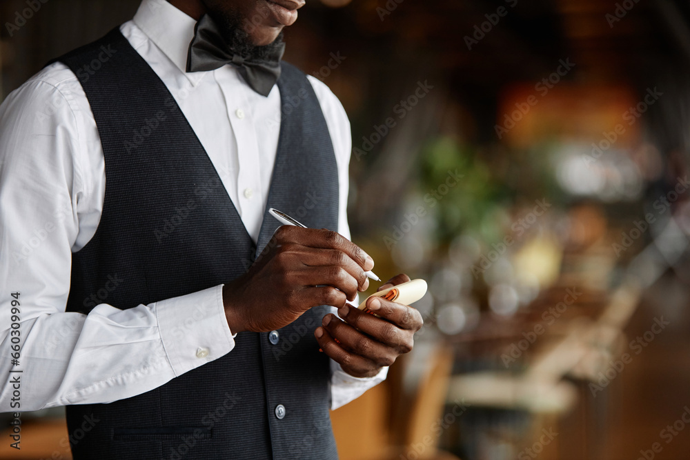 Side view cropped shot of elegant waiter holding notepad in restaurant ...
