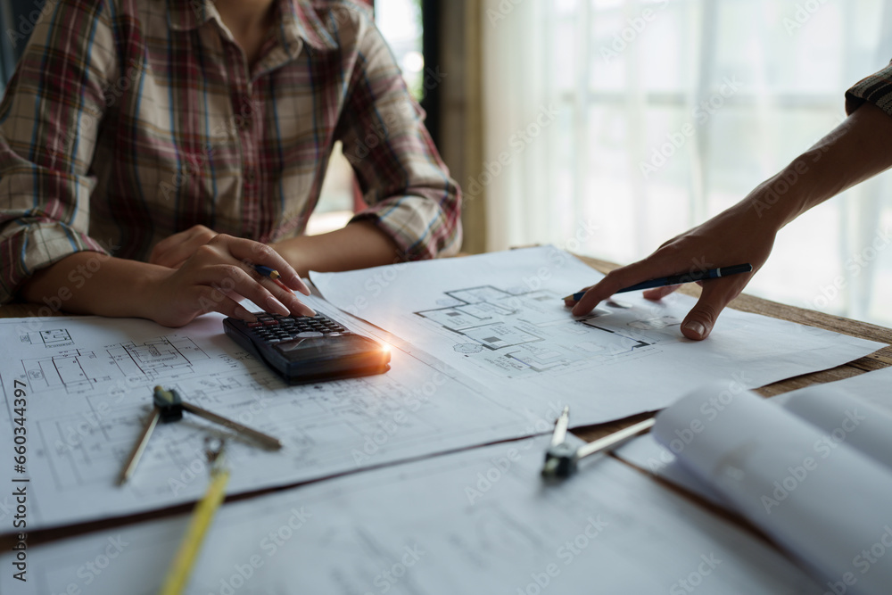 multi ethnic engineer brainstorming and measuring for cost estimating ...