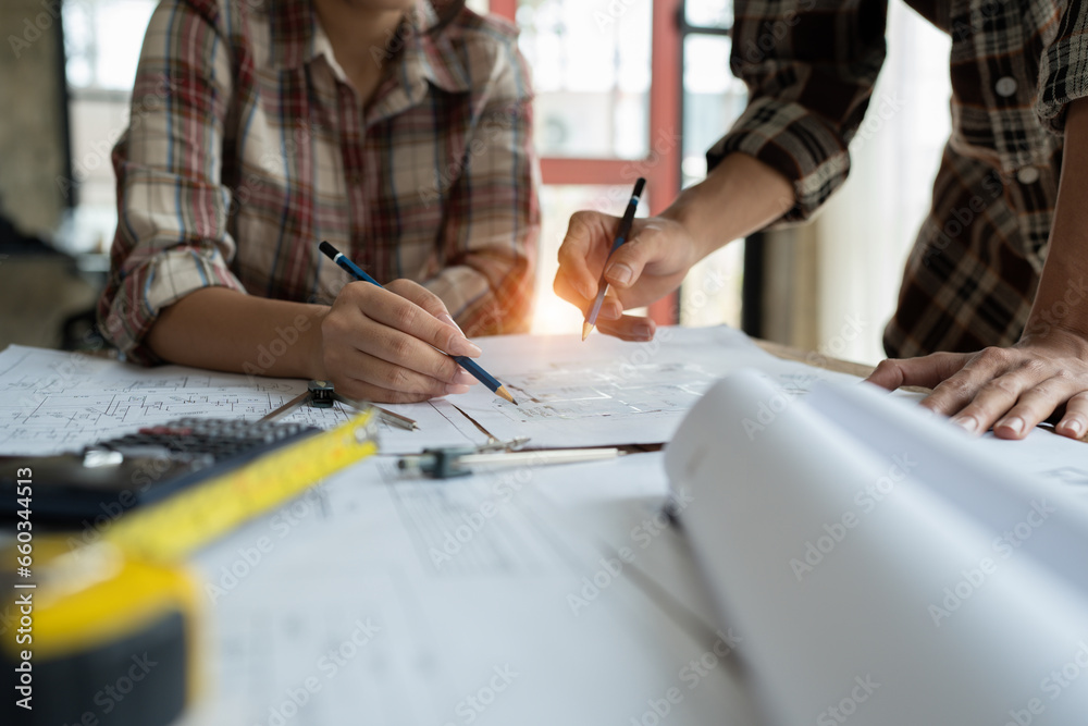 multi ethnic engineer brainstorming and measuring for cost estimating ...