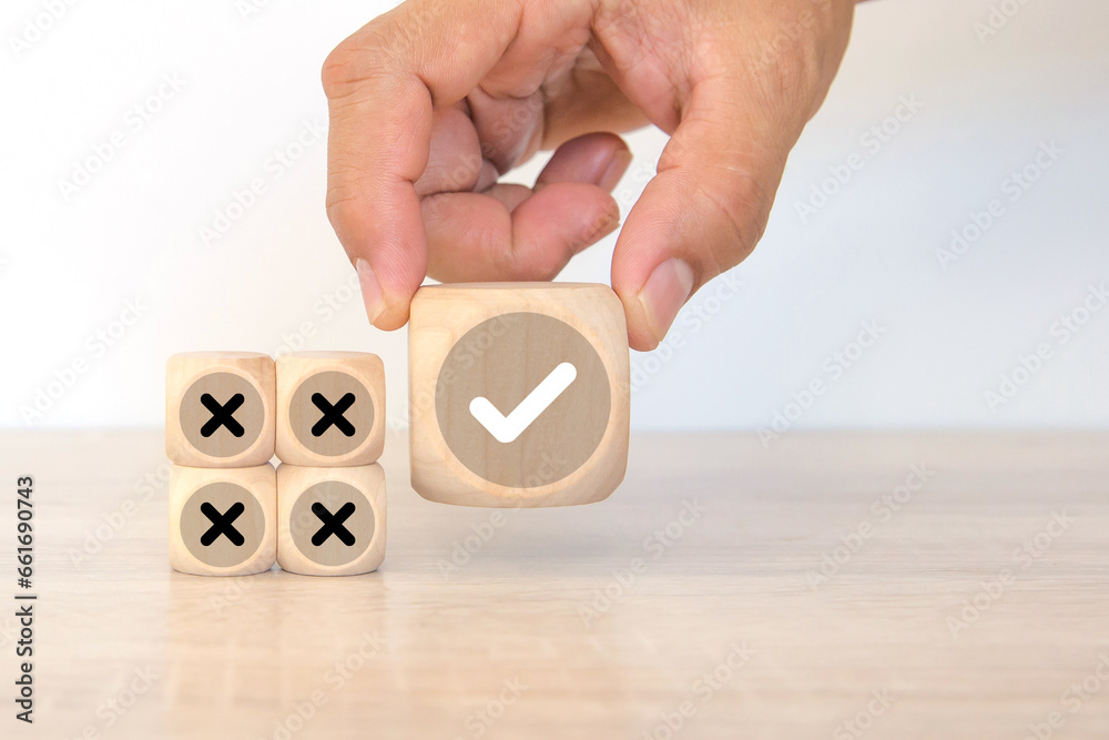 Hand choose check mark with cross symbol on cube wooden block stack for ...