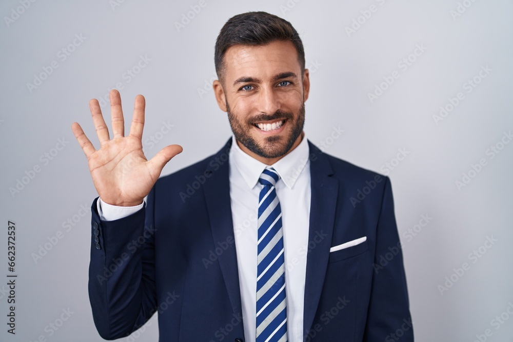 Handsome hispanic man wearing suit and tie showing and pointing up with ...