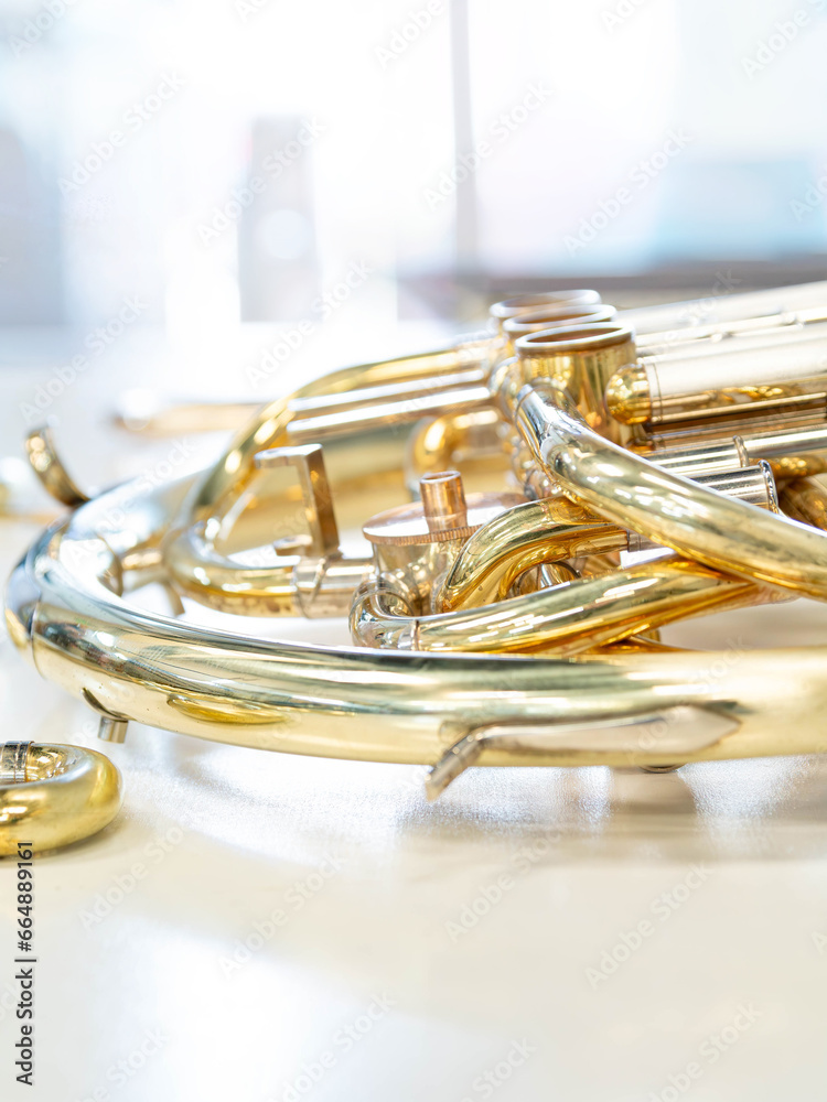 french horn waiting to be assembled once repaired on a workbench in a ...