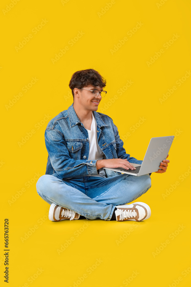 Male programmer working with laptop on yellow background Stock Photo ...
