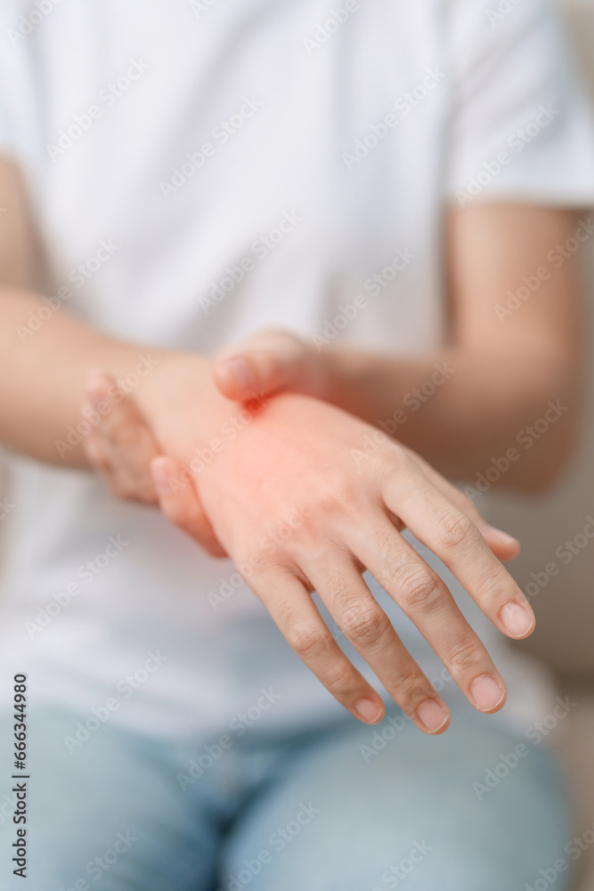 Woman having wrist pain during sitting on sofa at home, muscle ache due ...