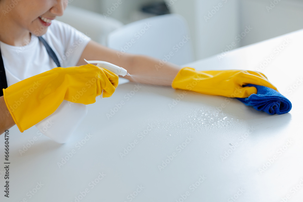 Asian female cleaner wiping down tables with cleaning spray, Wear ...